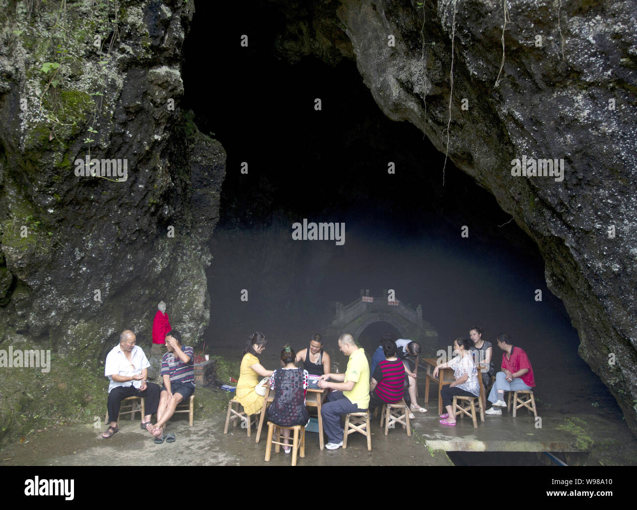 Local residents play mahjong or rest at a teahouse in a cave in Tangba ...