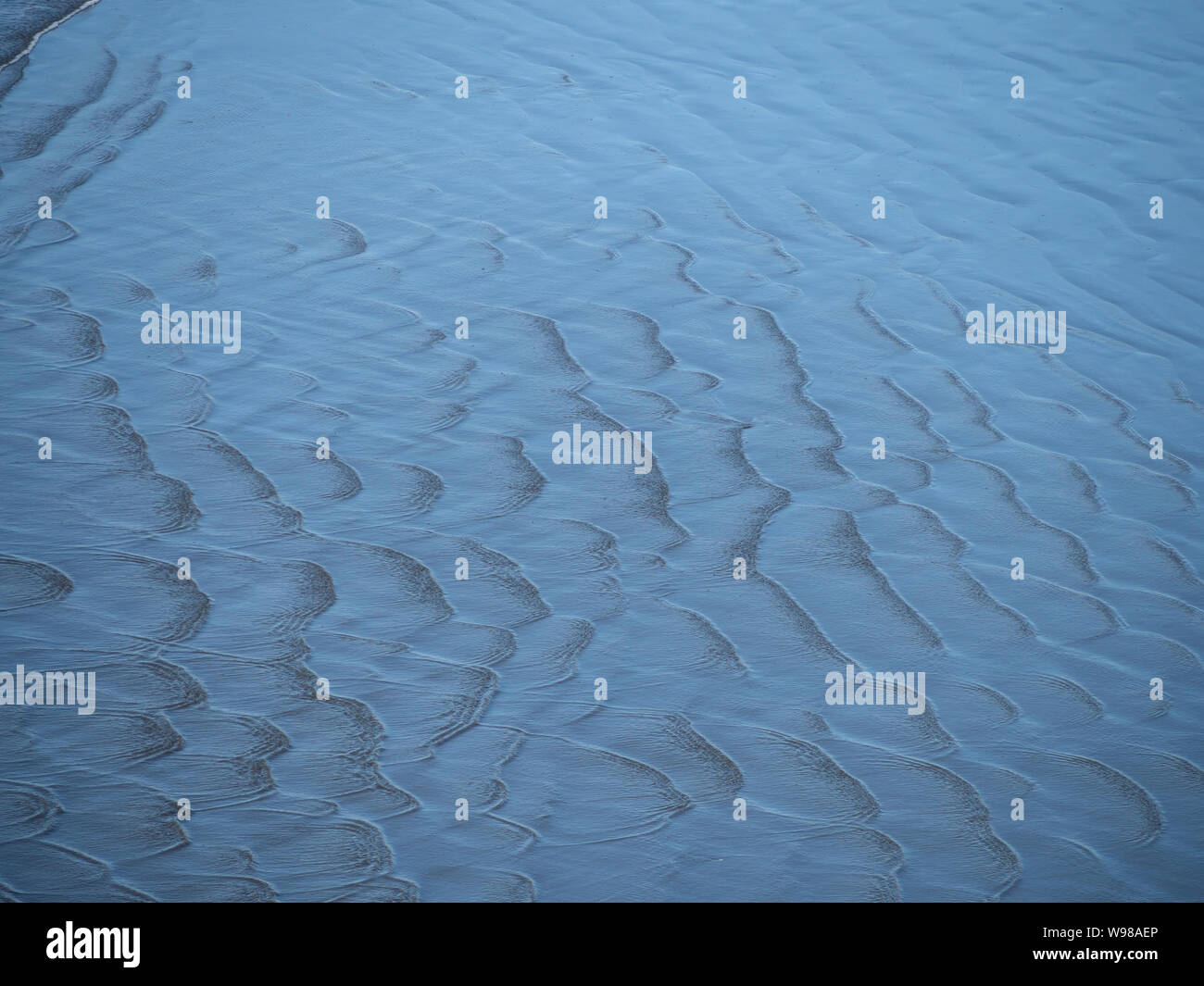 Tiny ripples of water on the sand at New Brighton beach, New Zealand ...
