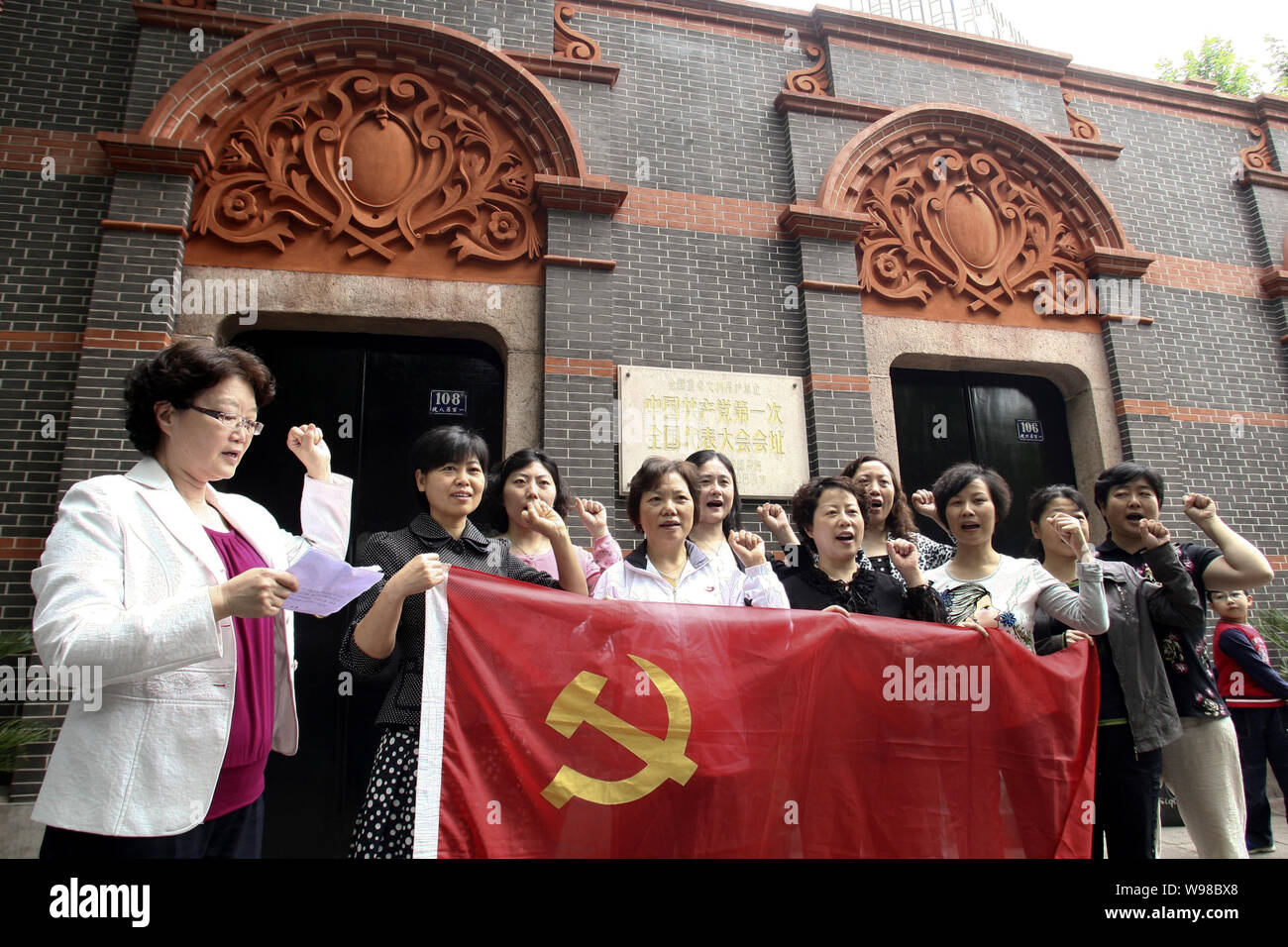 --FILE--Tourists show the flag of the Communist Party of China (CPC) in ...