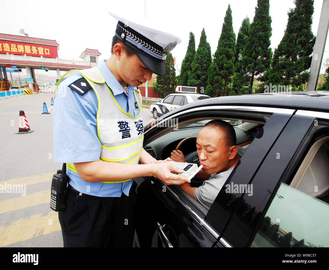 A Chinese police officer uses a detector to measure the alcohol level ...