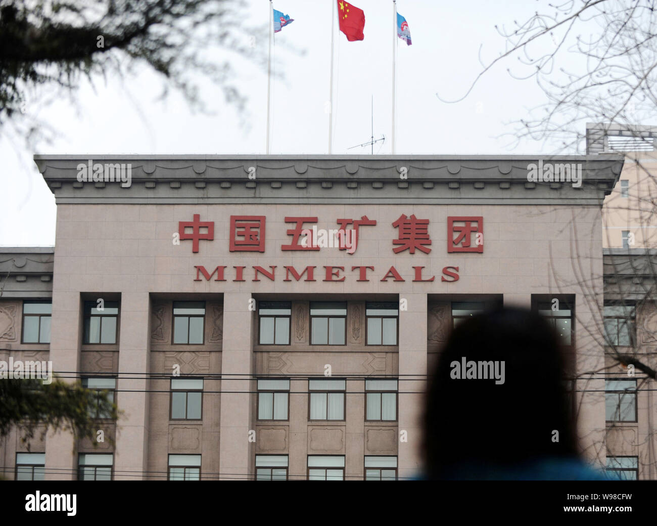 --FILE--A woman walks past the headquarters of China Minmetals ...