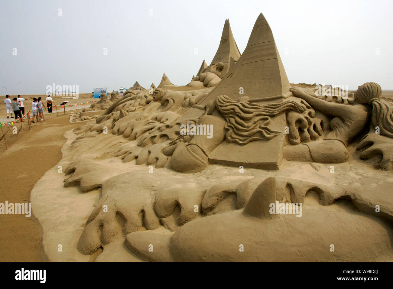 Tourists look at sand sculptures at a sand sculpture park in Weifang ...