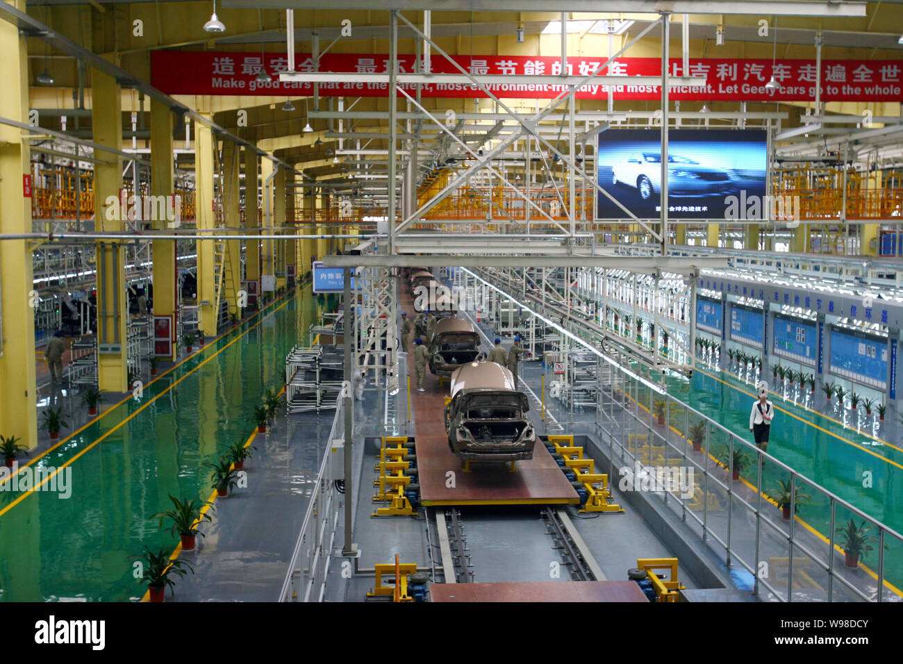 Chinese factory workers assemble Geely Emgrand EC7 cars on the assembly ...