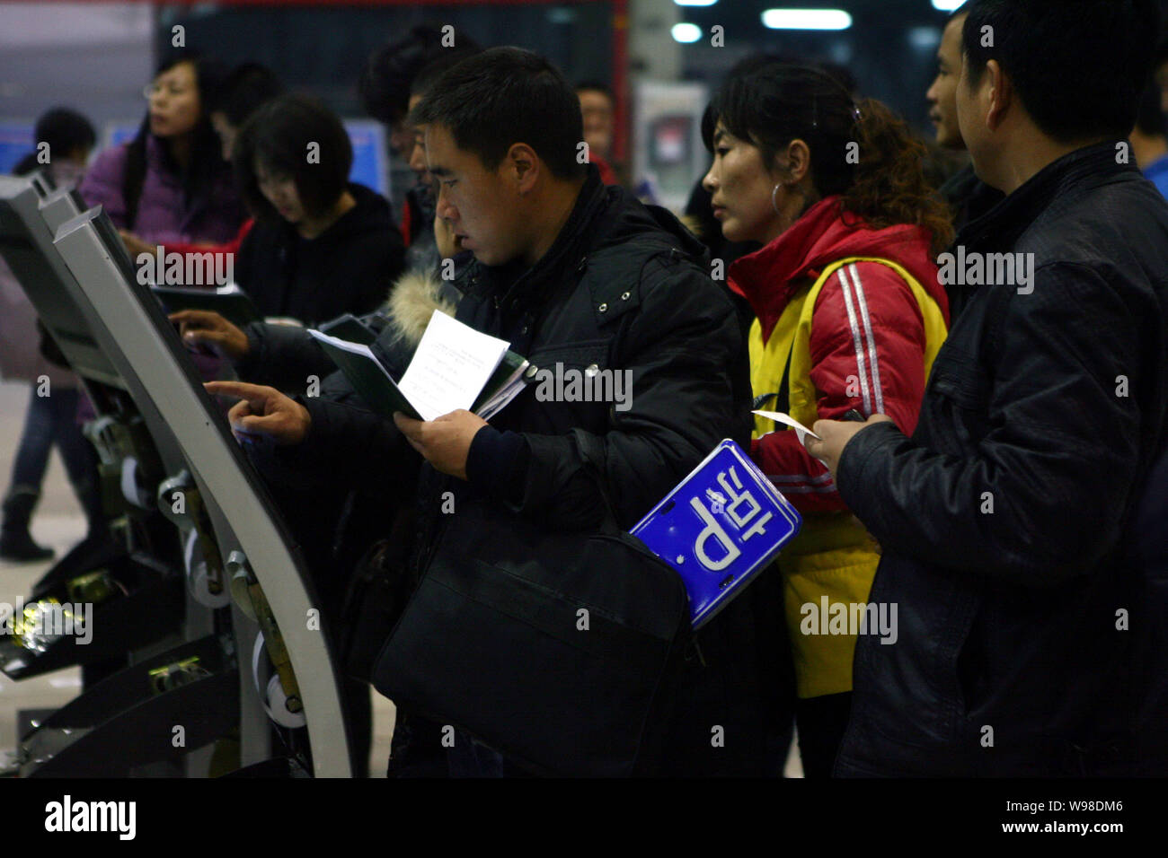 Chinese car license plate holders queue up to get queue numbers for the ...
