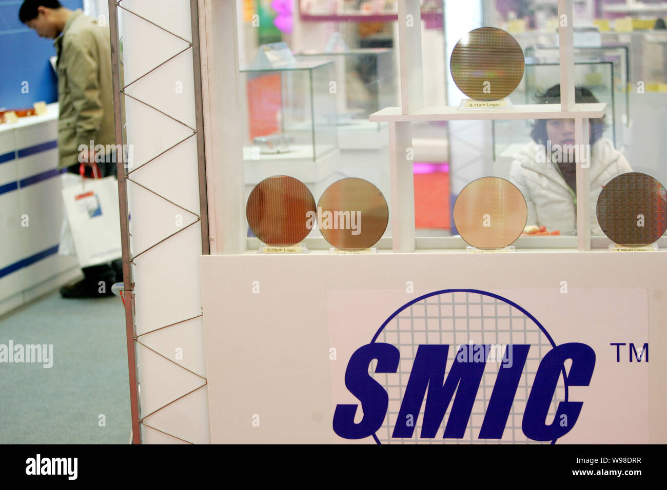 --FILE--Chinese visitors look at wafers on the booth of SMIC ...