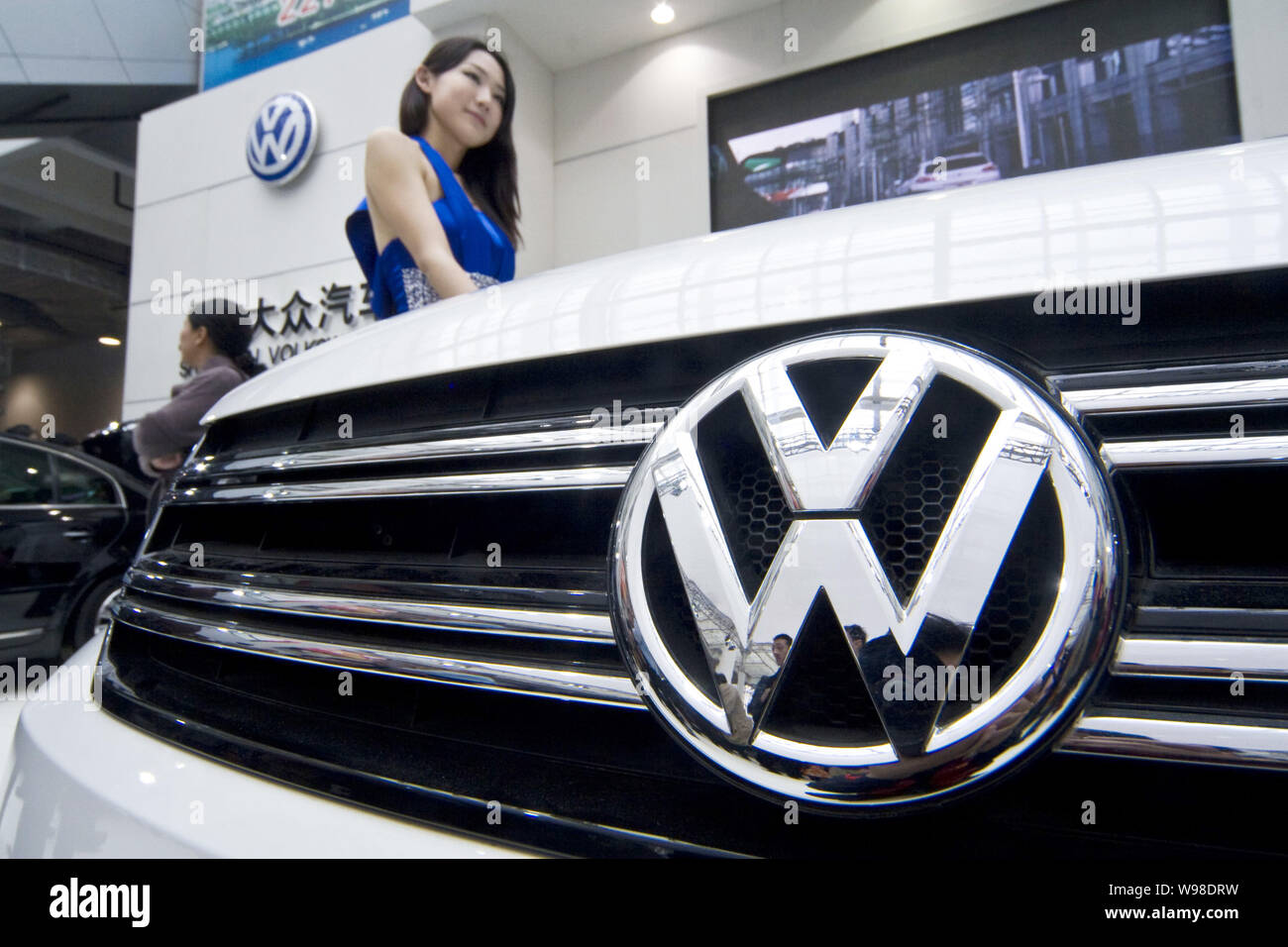 --FILE--A model poses next to a Volkswagen car on the booth of Shanghai ...