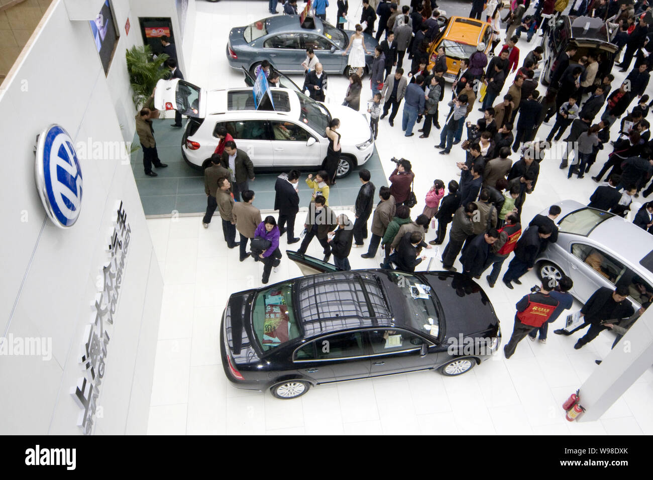 --FILE--Chinese visitors look at cars of Shanghai Volkswagen, a joint ...