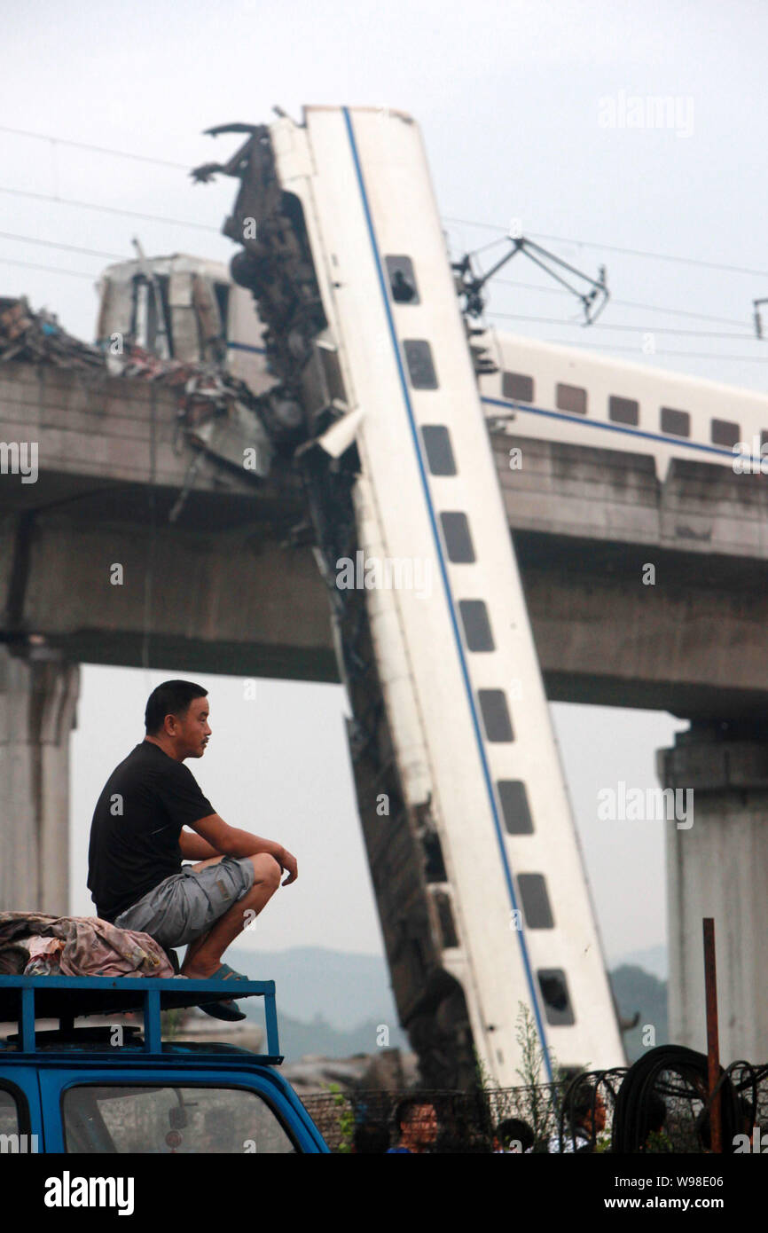 Onlookers look at the wreckage of the coaches of a CRH (China Railway ...