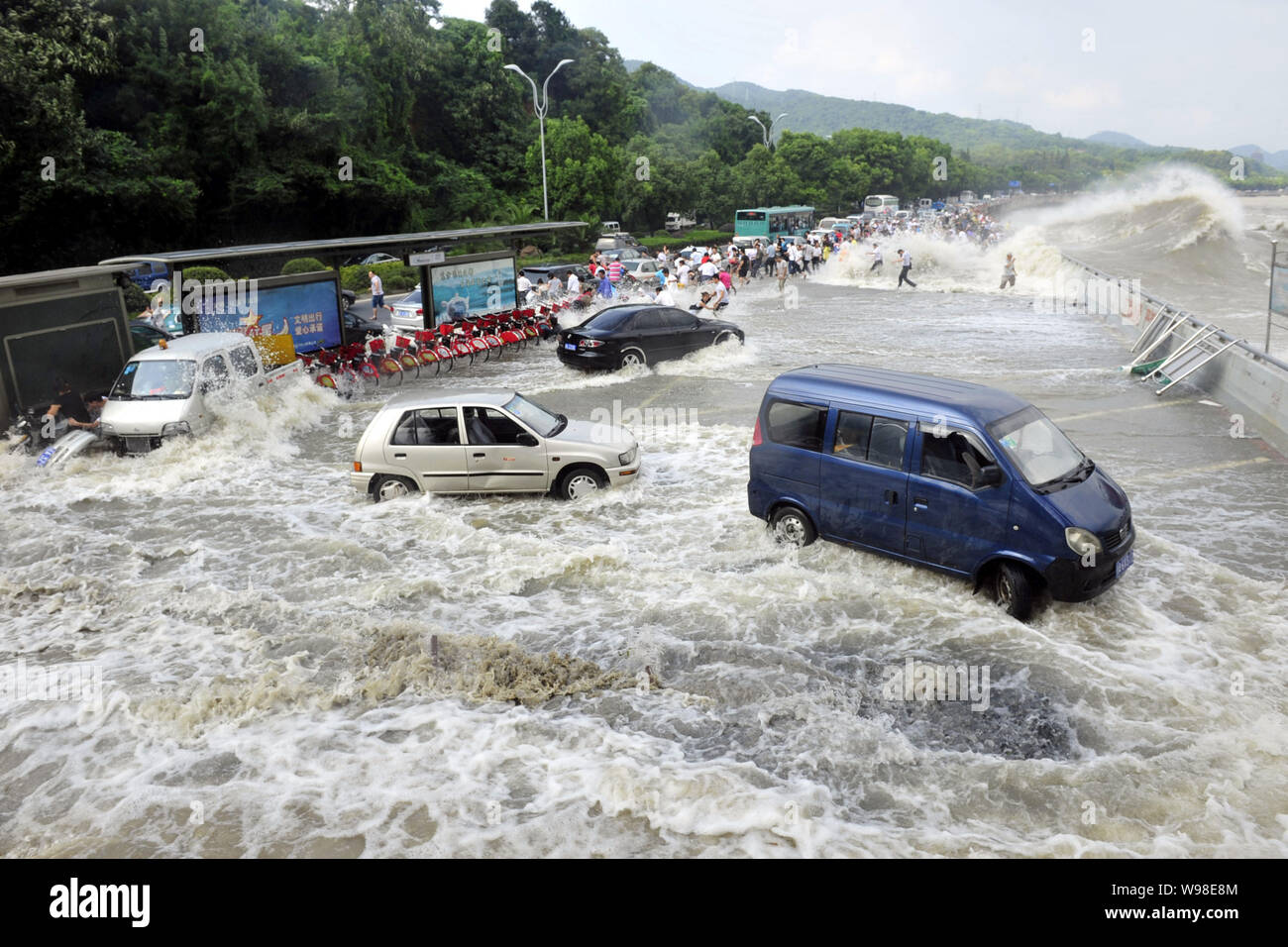 Visitors and local residents run as waves from a tidal bore surge past ...