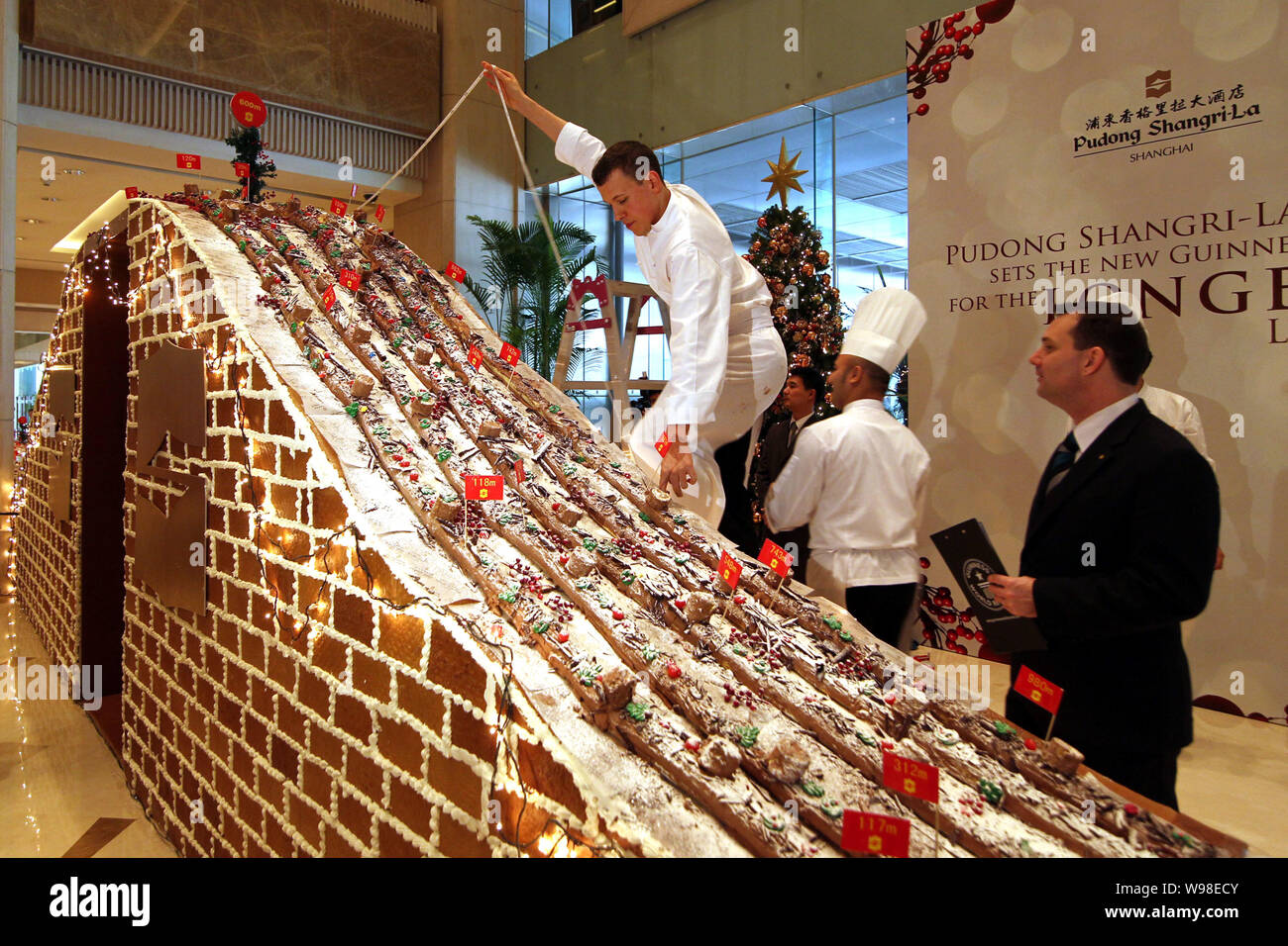 A chef helps to measure the length of the 1,068-meter-long Yule log ...