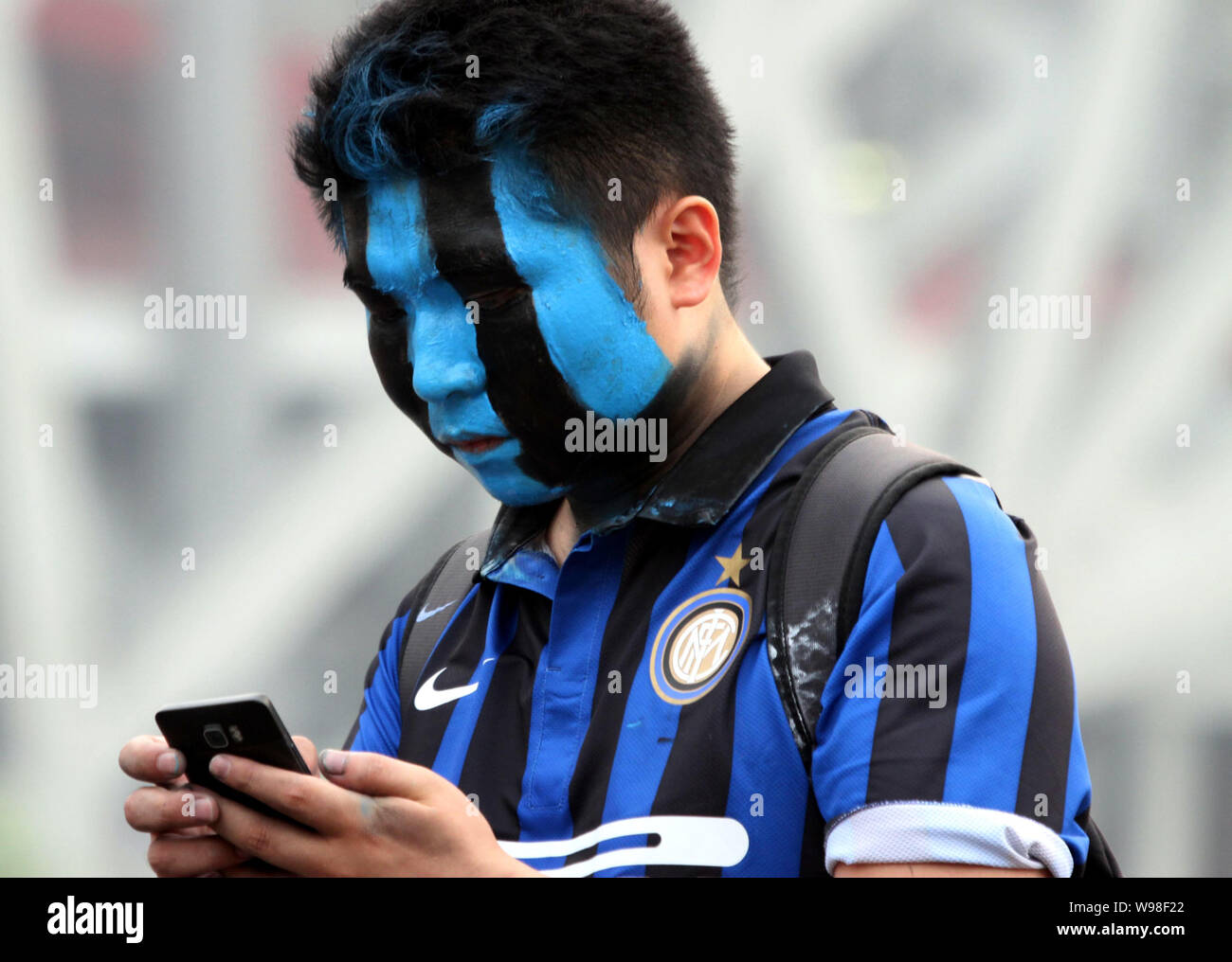 A fan of Inter Milan uses his mobile phone before the Italian Super Cup ...