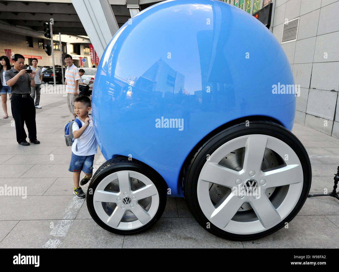 A young Chinese kid poses with a concept car of Volkswagens Peoples Car ...
