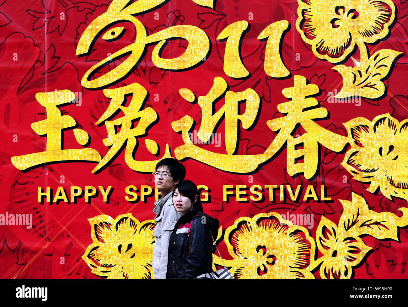 Local Chinese residents walk past a billboard with signs celebrating ...