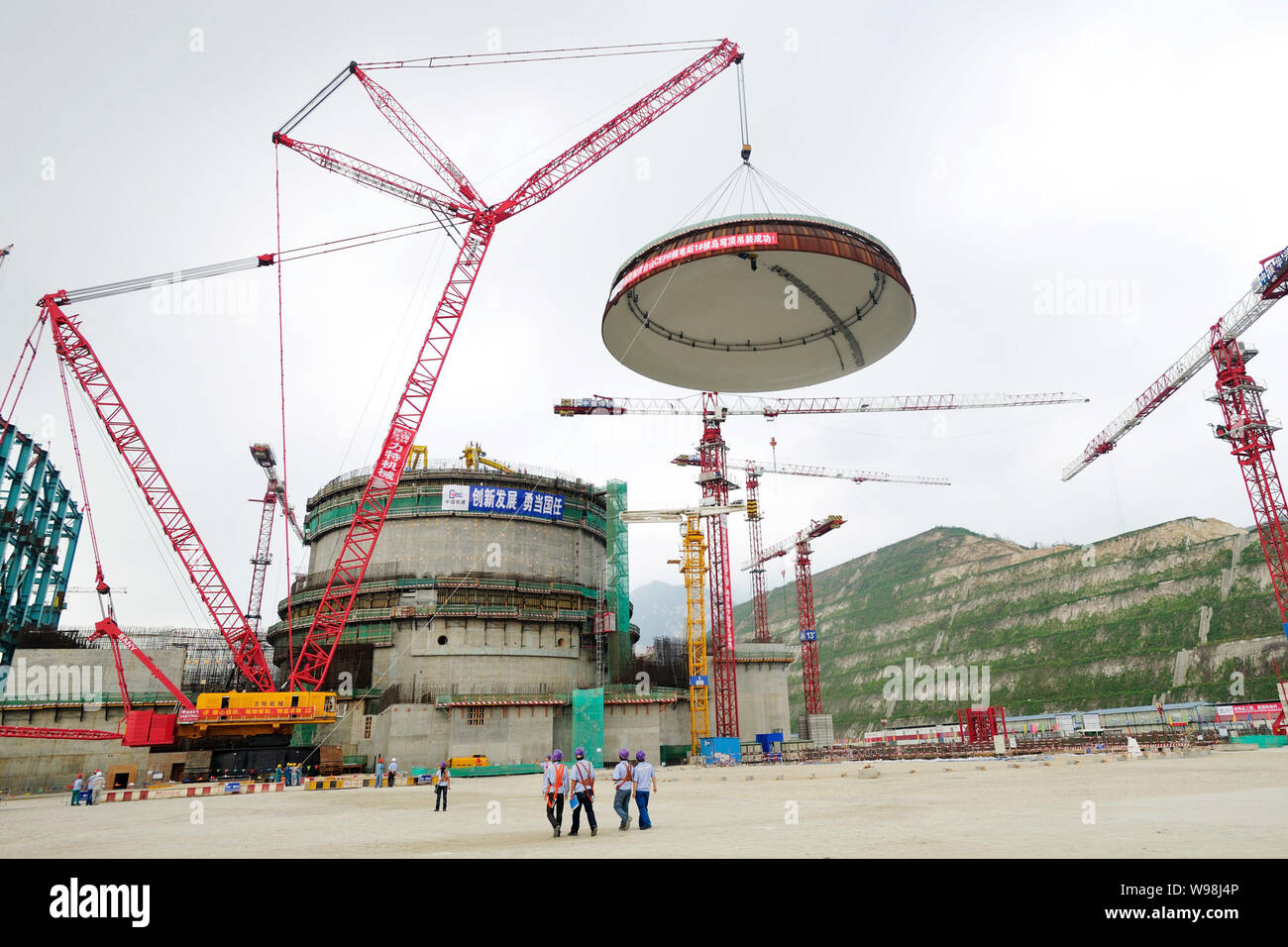 The dome of a containment structure is being hoisted to top of the ...
