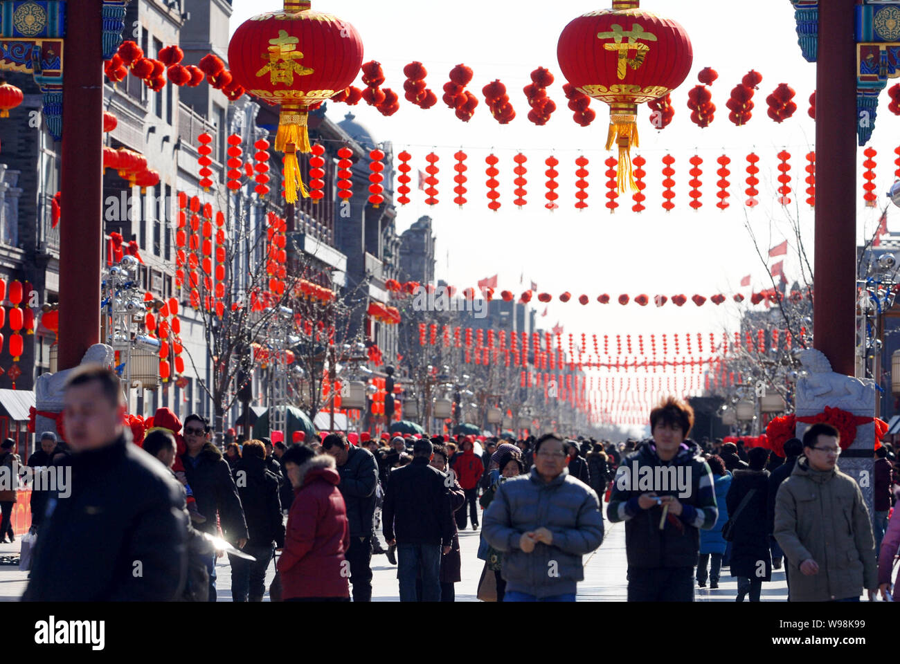 Local Chinese residents walk under red lanterns being displayed to ...