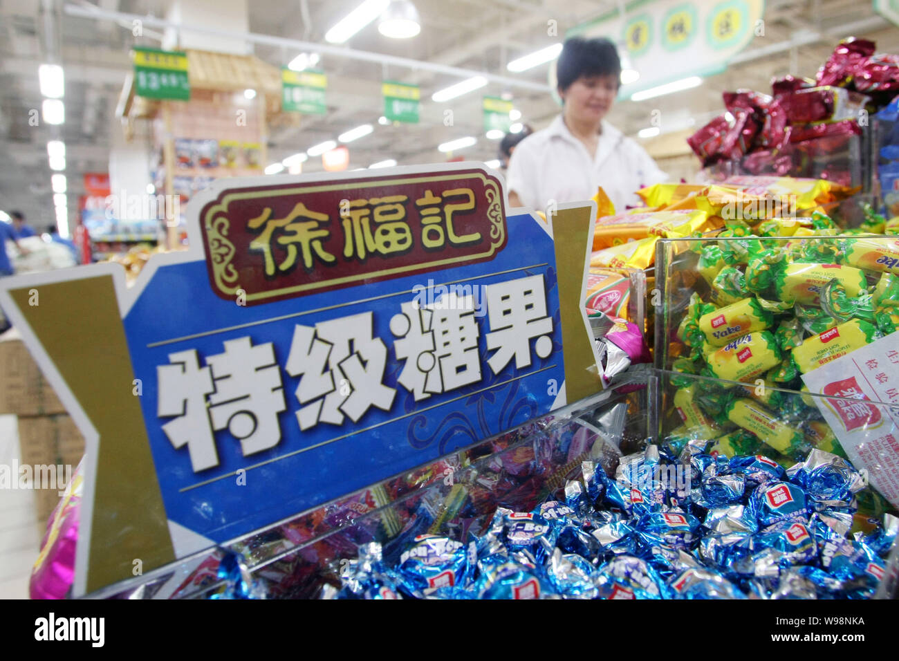 A customer buys Hsu Fu Chi sweets in a supermarket in Shanghai, China ...