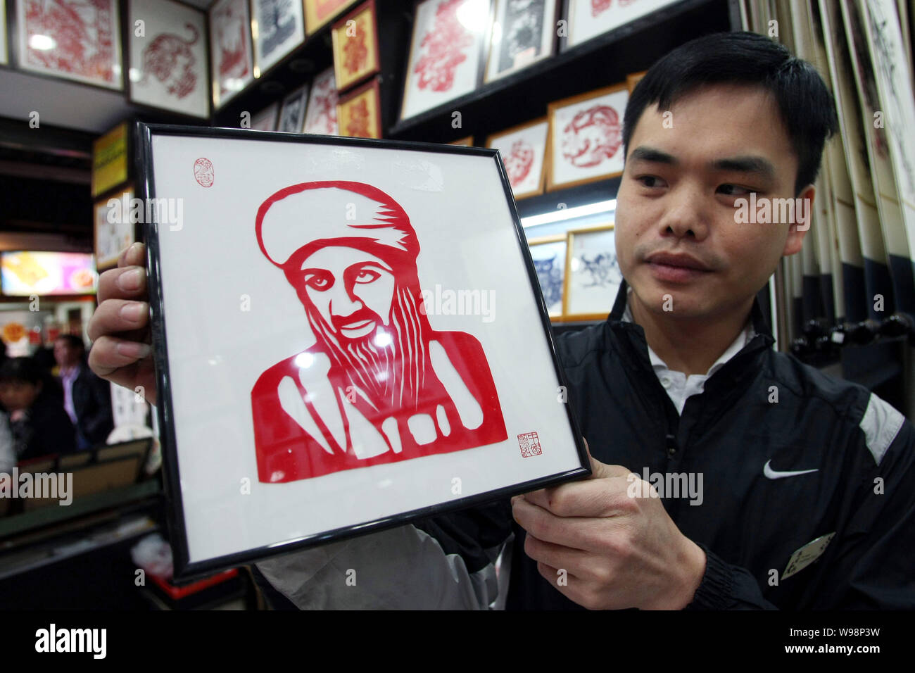 A man shows a paper-cut souvenir of Osama bin Laden in a shop at the ...