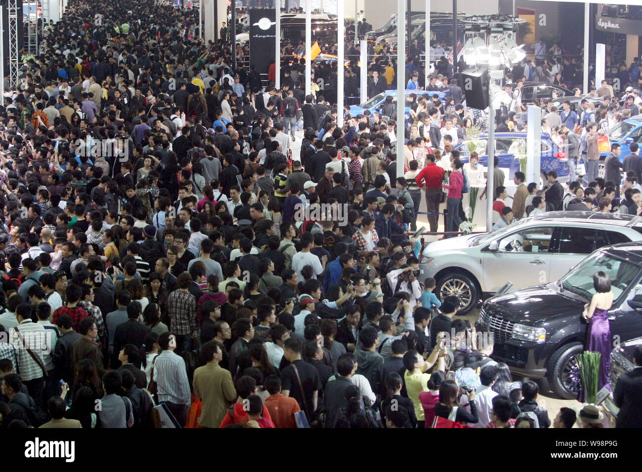 Visitors crowd booths at the 14th Shanghai International Automobile ...
