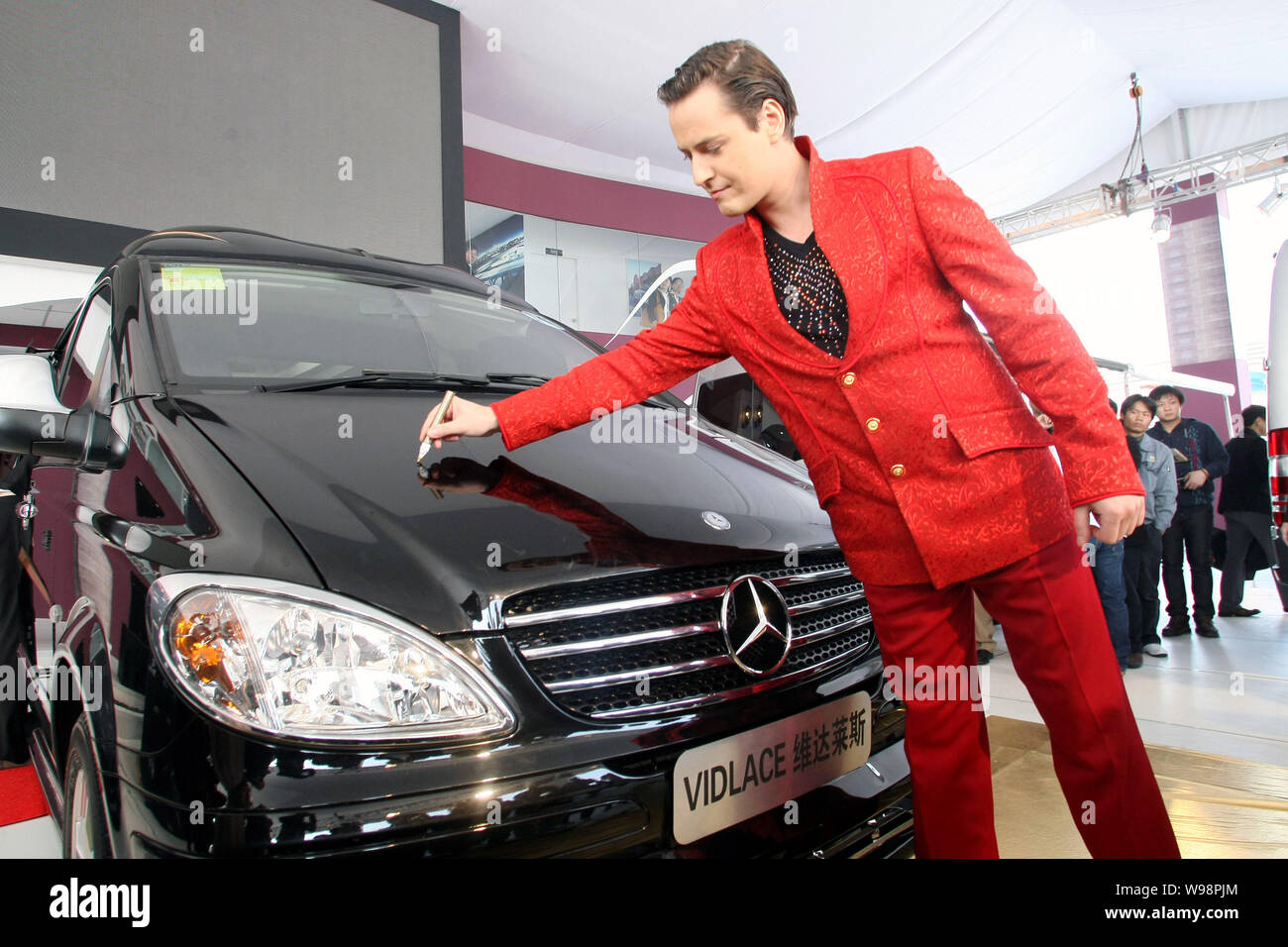 Russian singer Vitas signs his name on the car at the booth of Mercedes ...