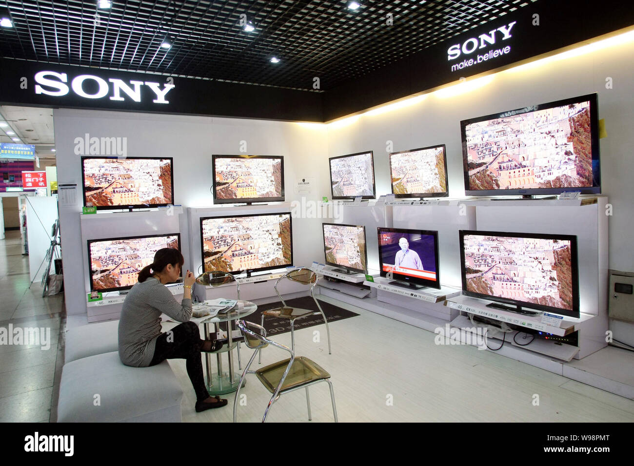 --FILE--A saleswoman has a meal in front of Sony Bravia LCD and LED ...