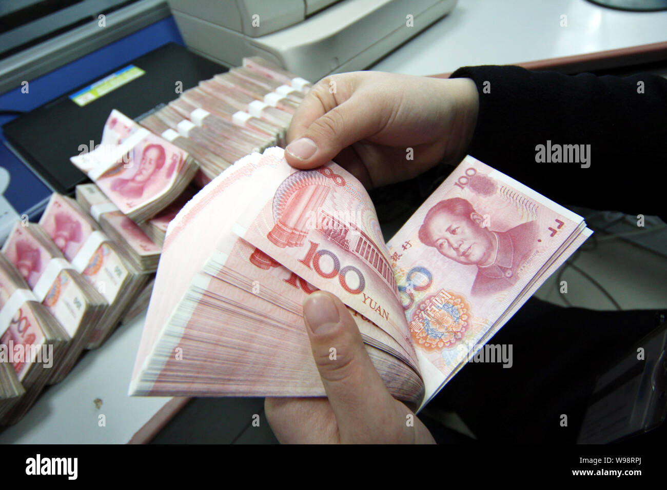 --FILE--A Chinese clerk counts RMB (renminbi) yuan banknotes at a bank ...