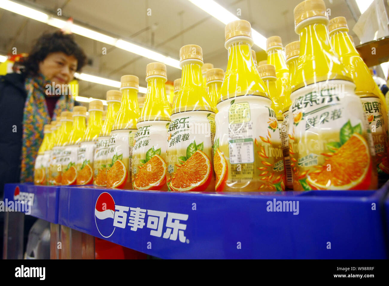 A Chinese customer shops for orange juice of PepsiCo at a supermarket ...