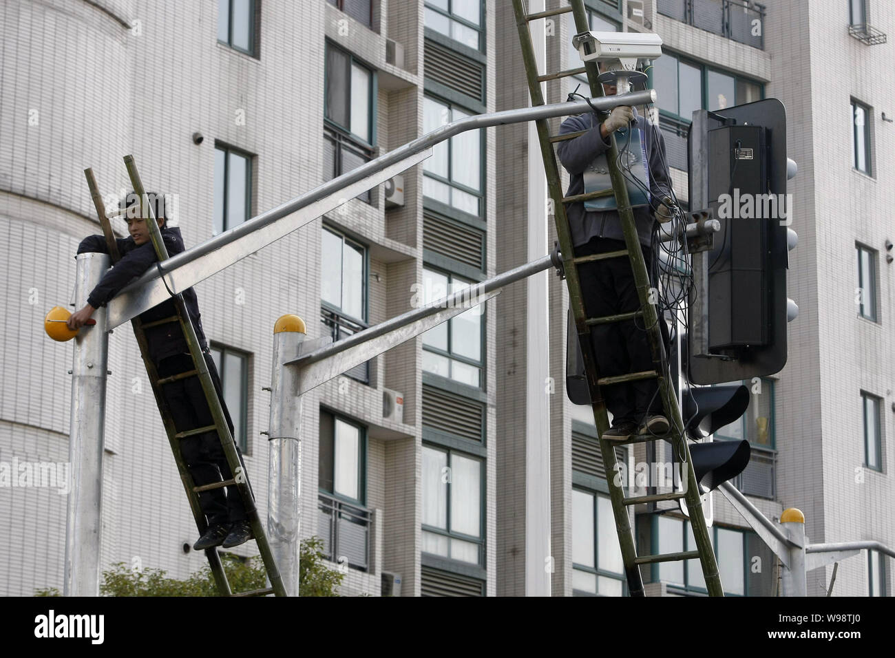 --FILE--A Chinese worker installs an electronic surveillance camera on ...