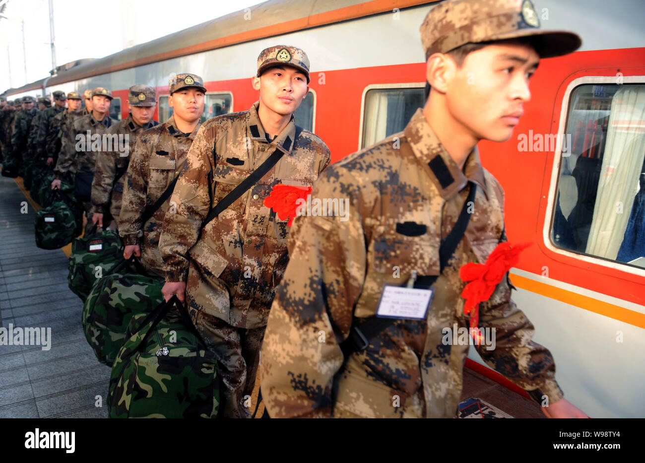 Newly-recruited military soldiers line up to board a train before ...