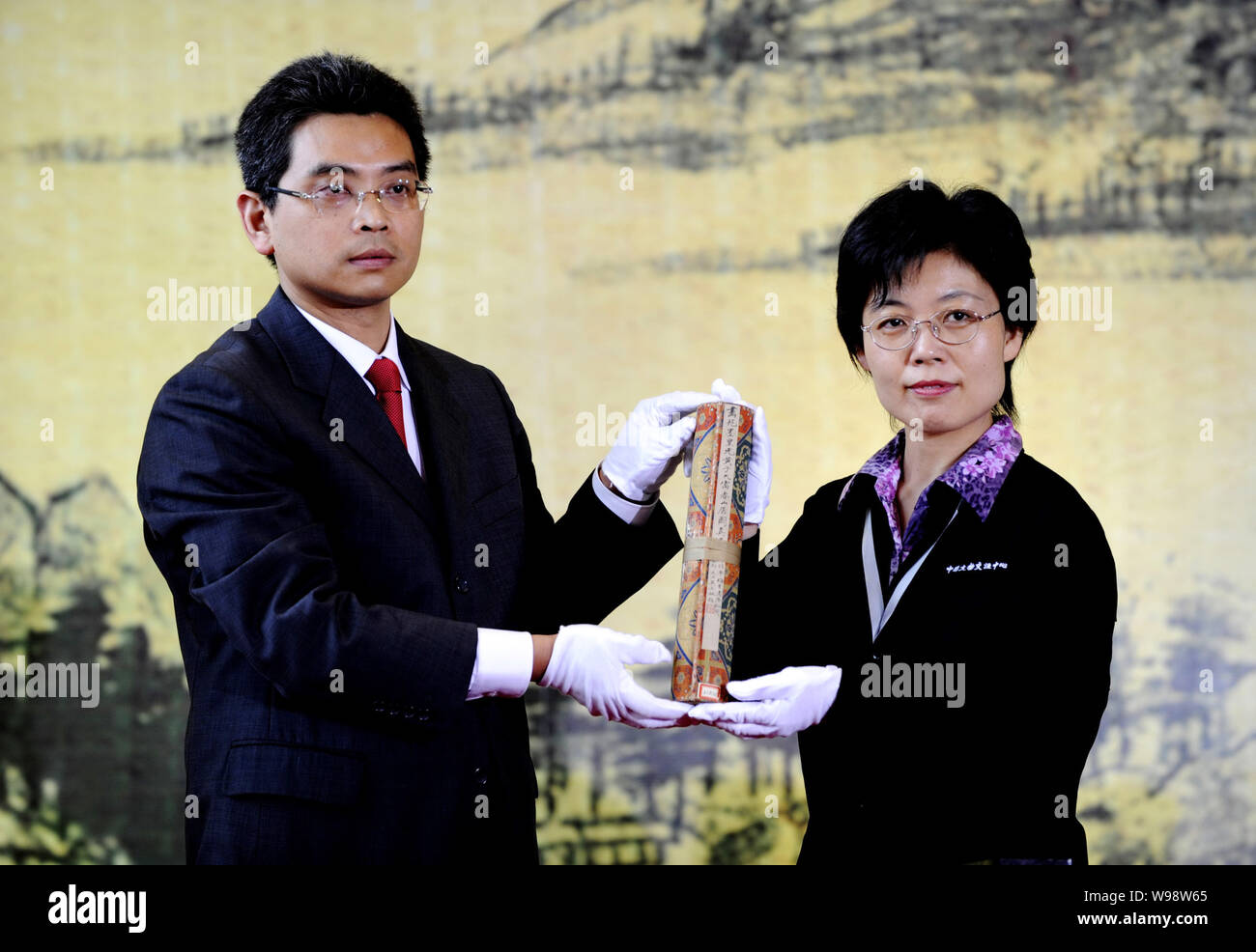 Chinese staff hold The Leftover Mountain Painting, the smaller half of ...