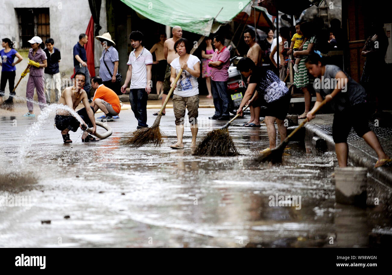 Local Chinese residents clean up the street after floods receded in ...