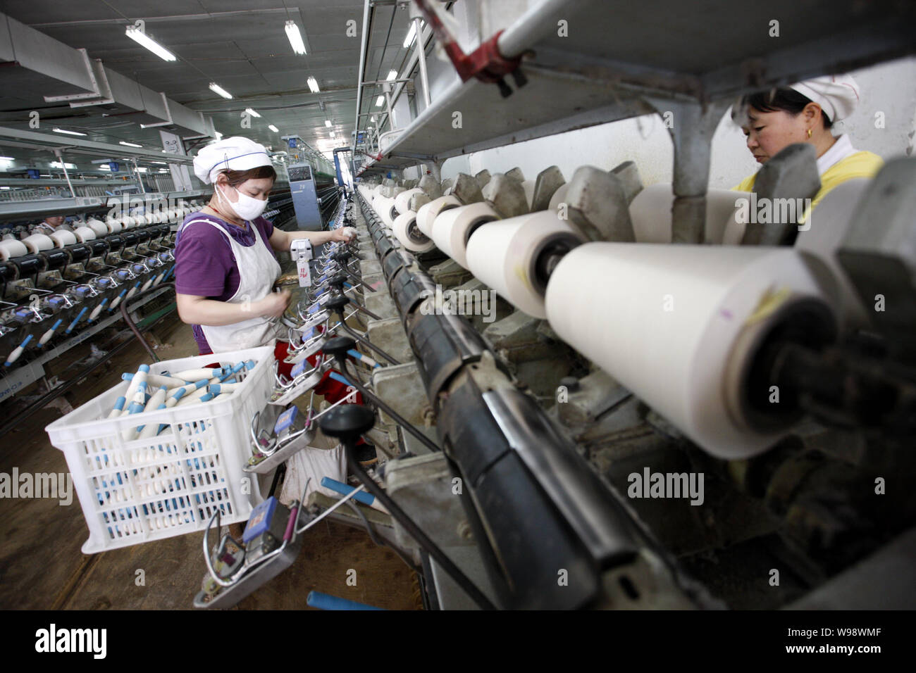 Female Chinese workers handle the production of yarn to be exported to ...