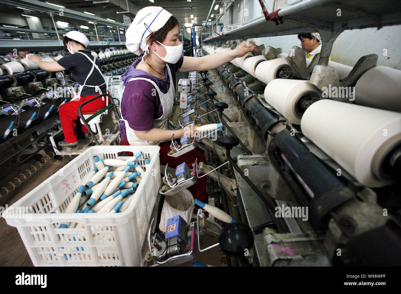 Female Chinese workers handle the production of yarn to be exported to ...