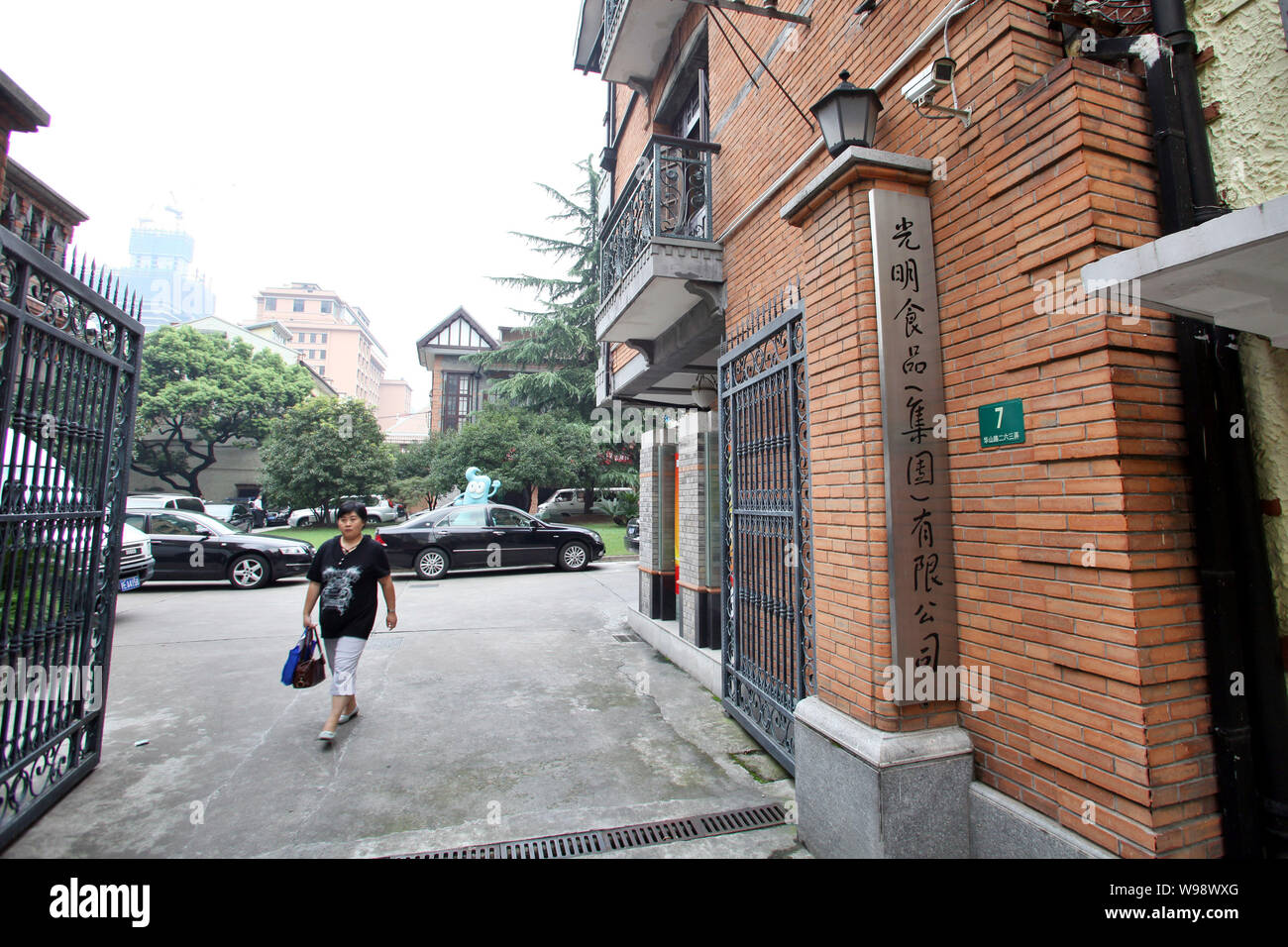 --FILE--A woman walks out from the headquarters of of Bright Food Group ...