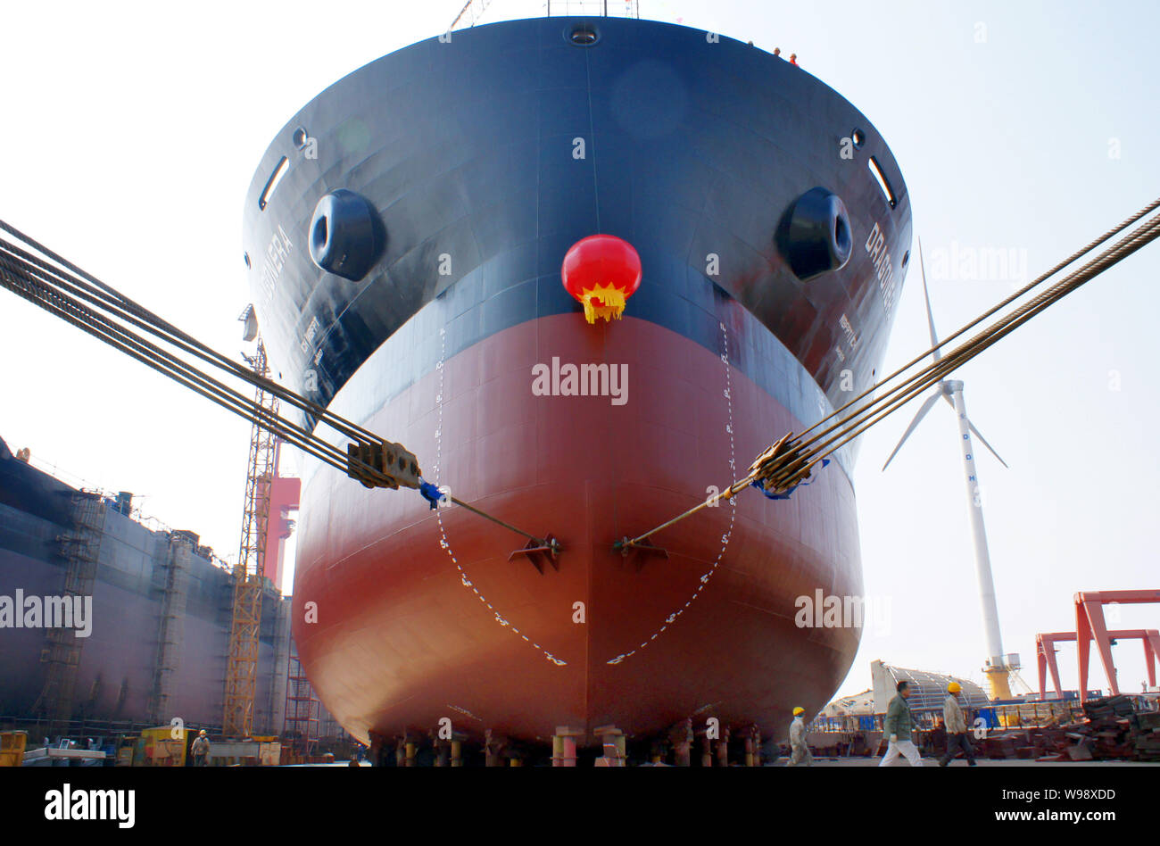 --FILE--Workers look at a bulk cargo ship to be launched at the ...