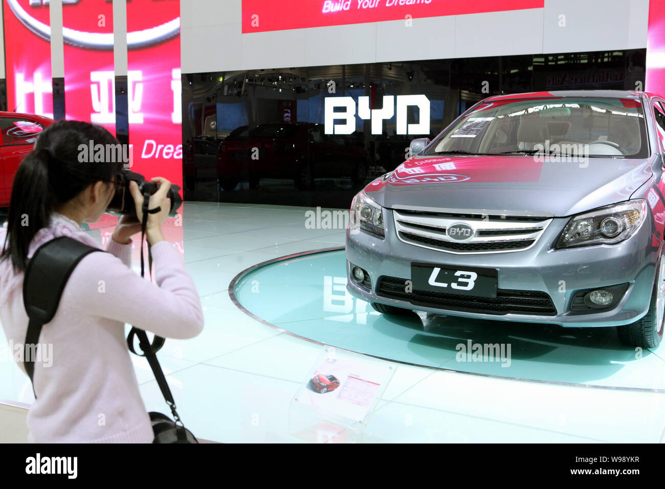 --File-- A Chinese woman takes photos of a BYD L3 during the 8th China ...