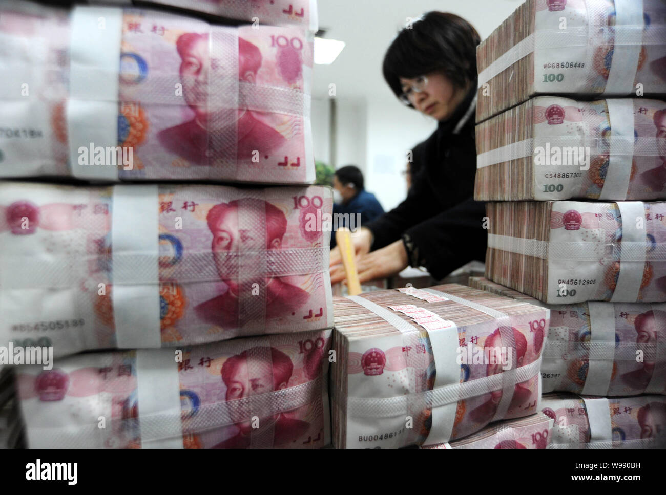 Chinese clerks count RMB (renminbi) yuan banknotes at a bank in Haian ...
