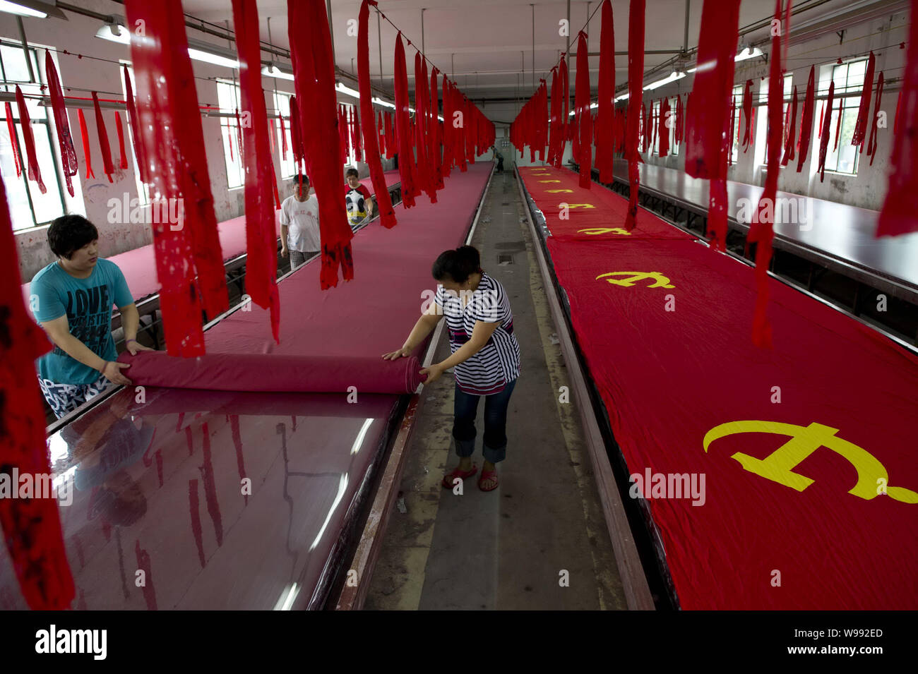 Workers make flags of the Communist Party of China (CPC) at Beijing ...