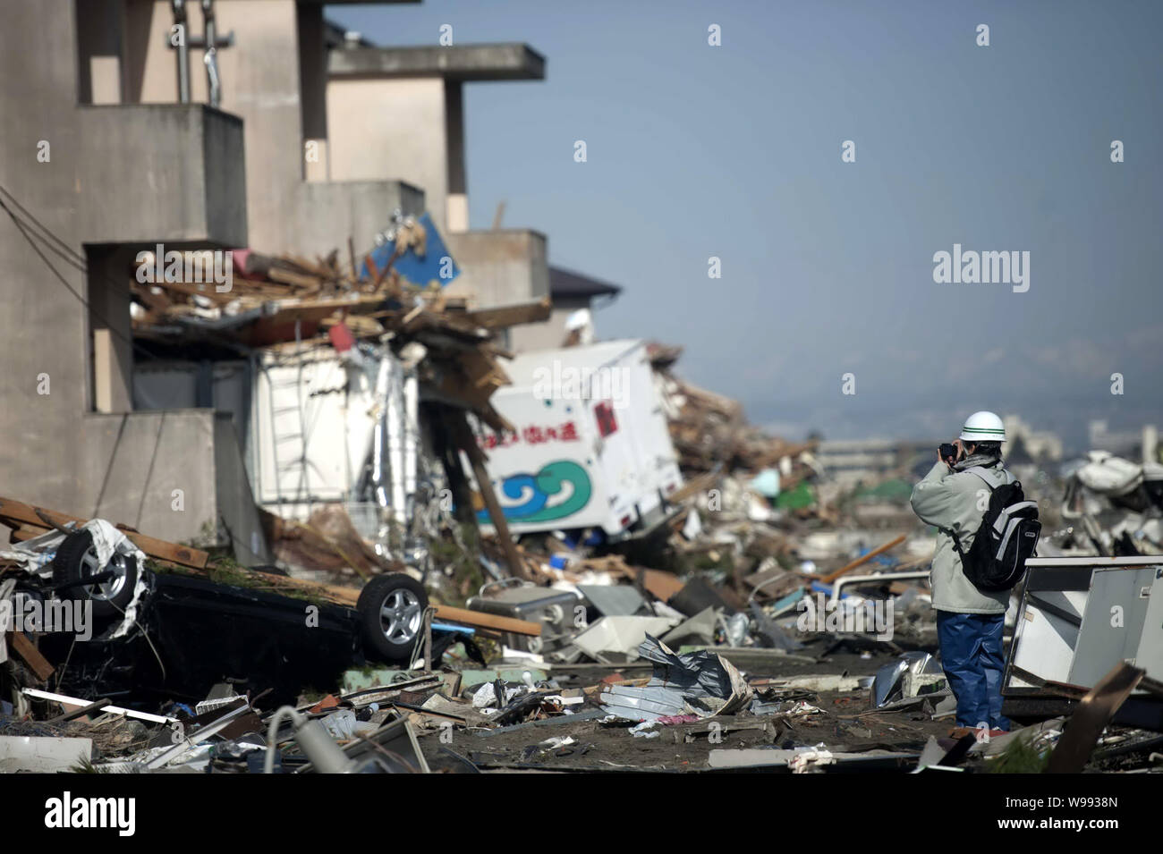 A man takes photos of the debris of the tsunami devastation caused by ...