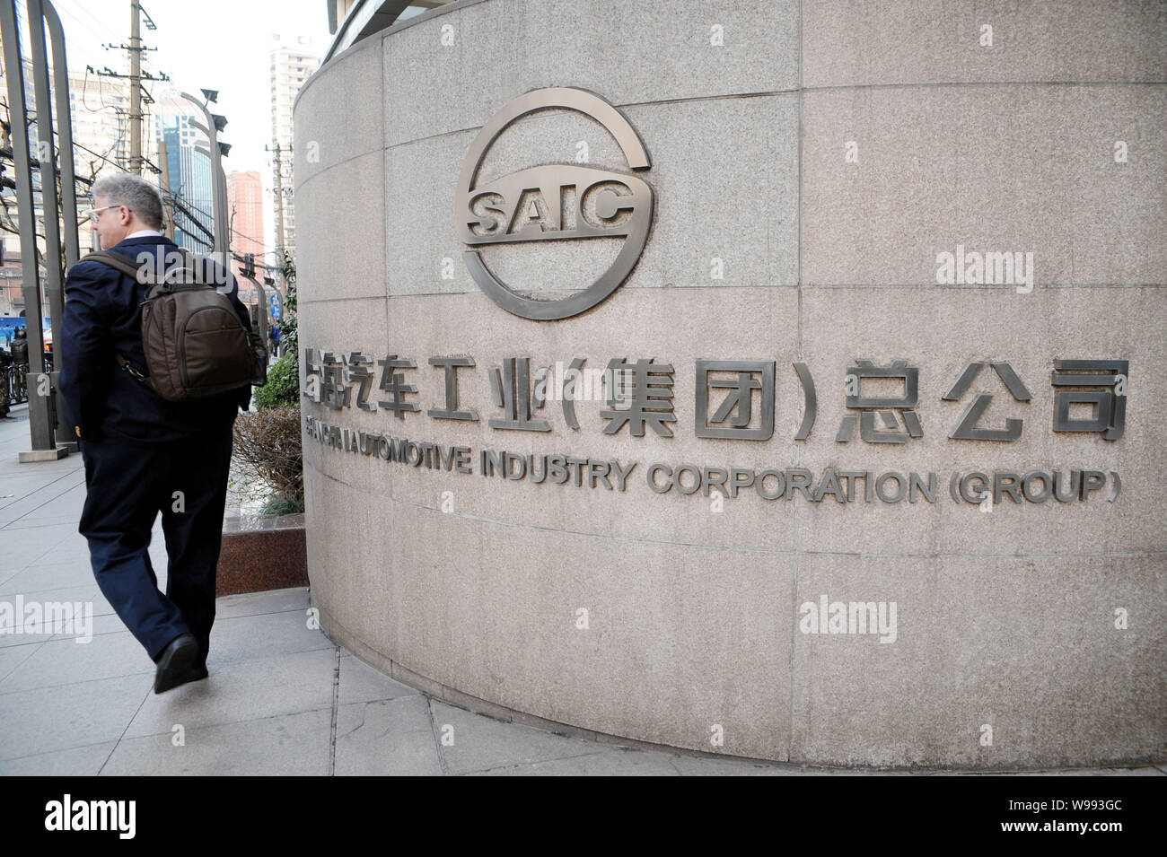 --FILE--A man walks past the headquarters of SAIC (Shanghai Automotive ...