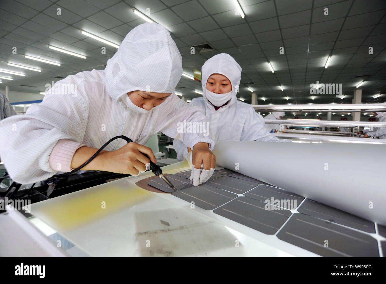 Chinese workers weld photovoltaic cells at the plant of Eoplly New ...