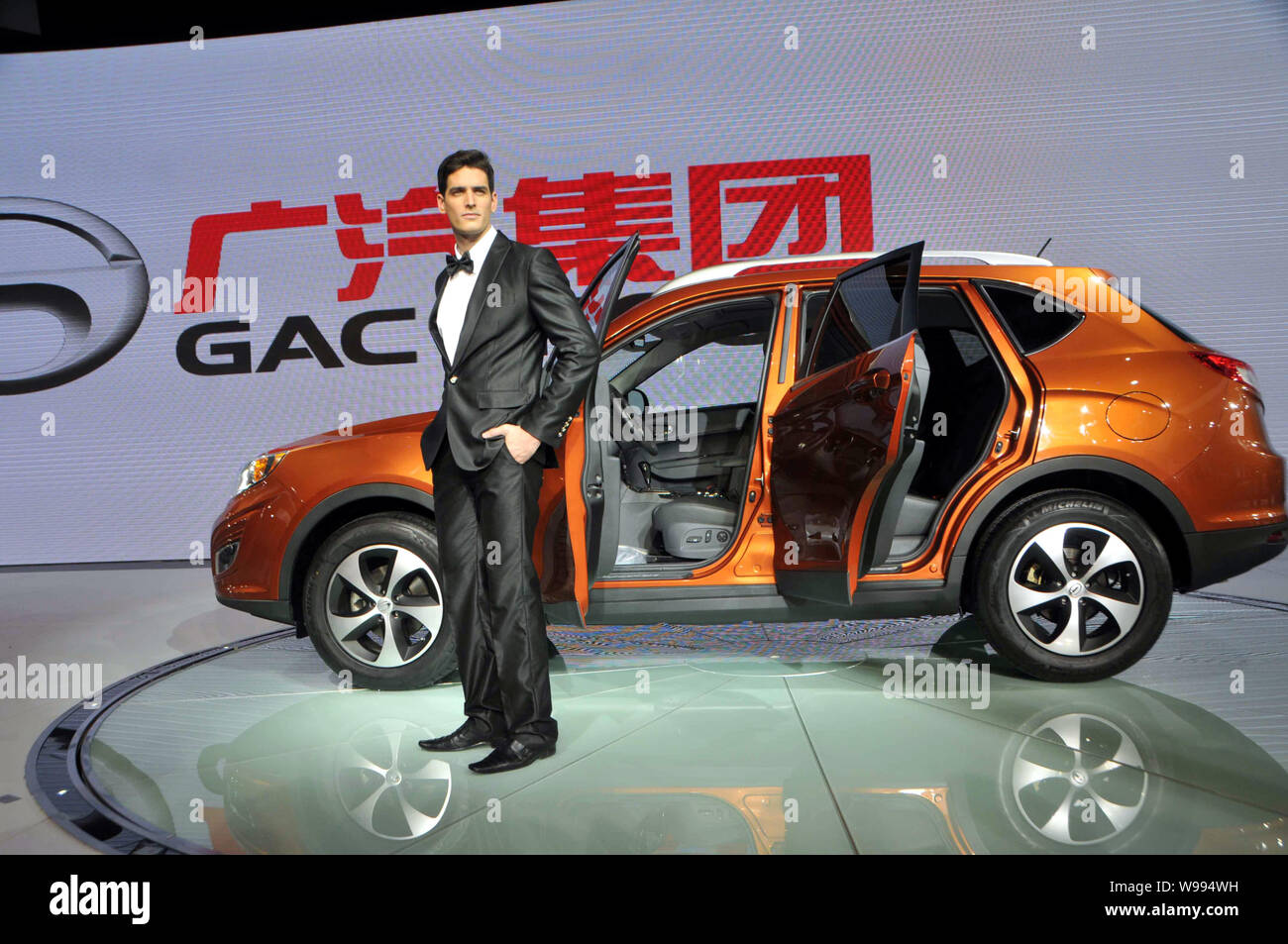 A model poses with a Trumpchi GS5 of GAC Group at a debut ceremony ...