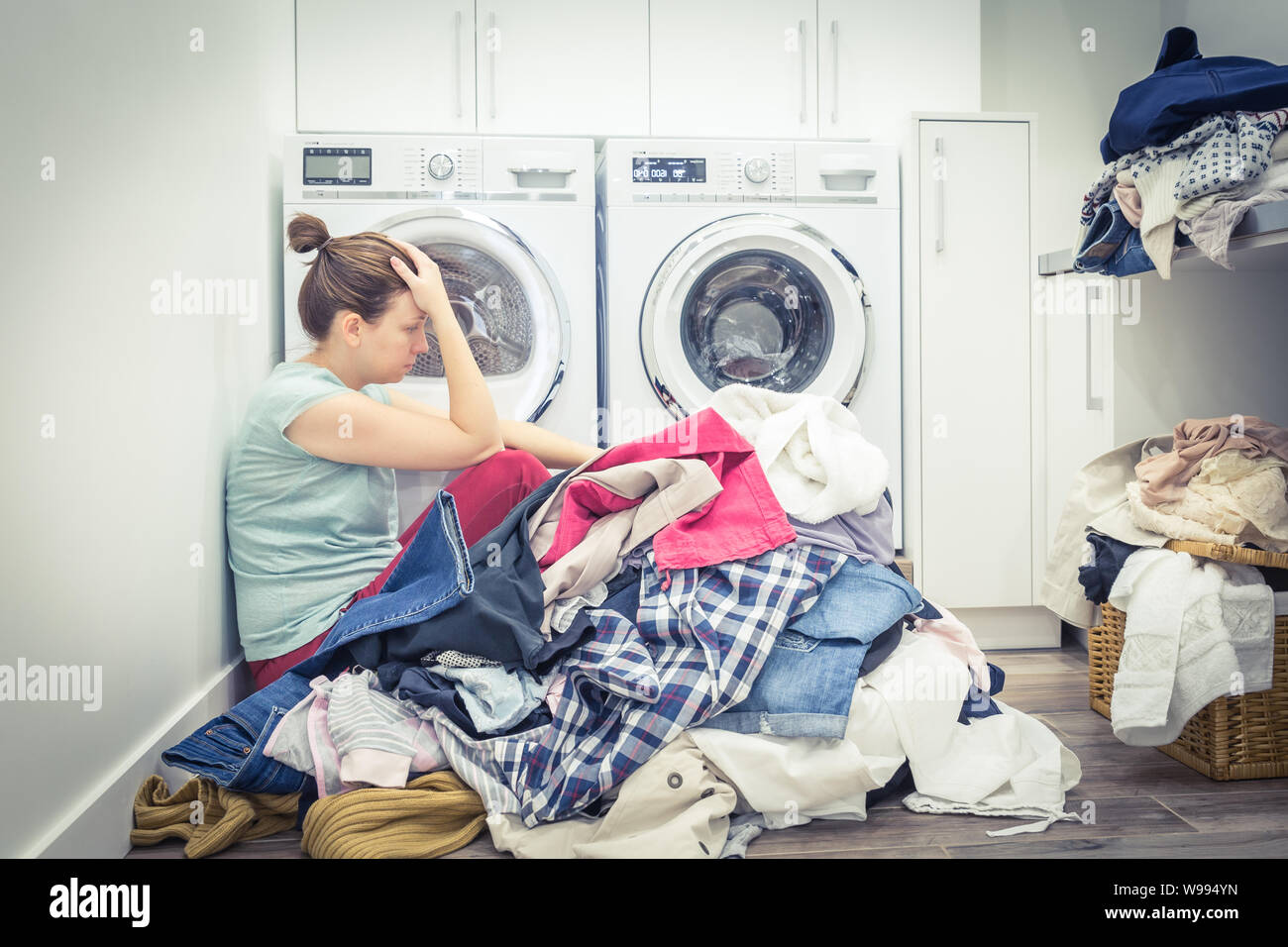 Unhappy Stressed Woman with Pile Of Clothes Near Washing Machine in ...