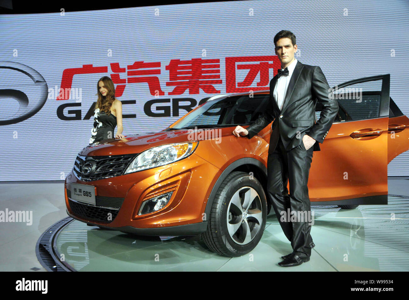 Models pose with a Trumpchi GS5 of GAC Group at a debut ceremony during ...