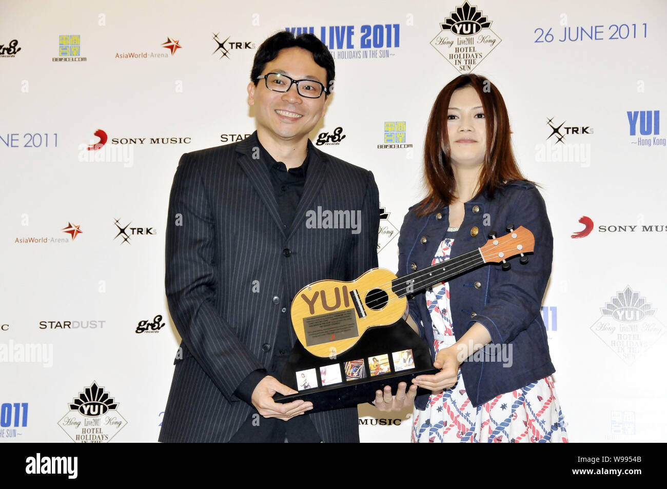 Japanese singer YUI, right, is presented a gift at a press conference ...
