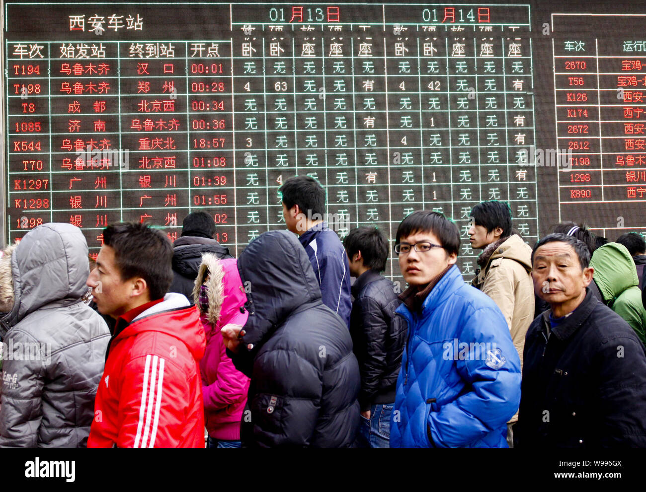 Chinese passengers queue up to buy train tickets at the ticket center ...