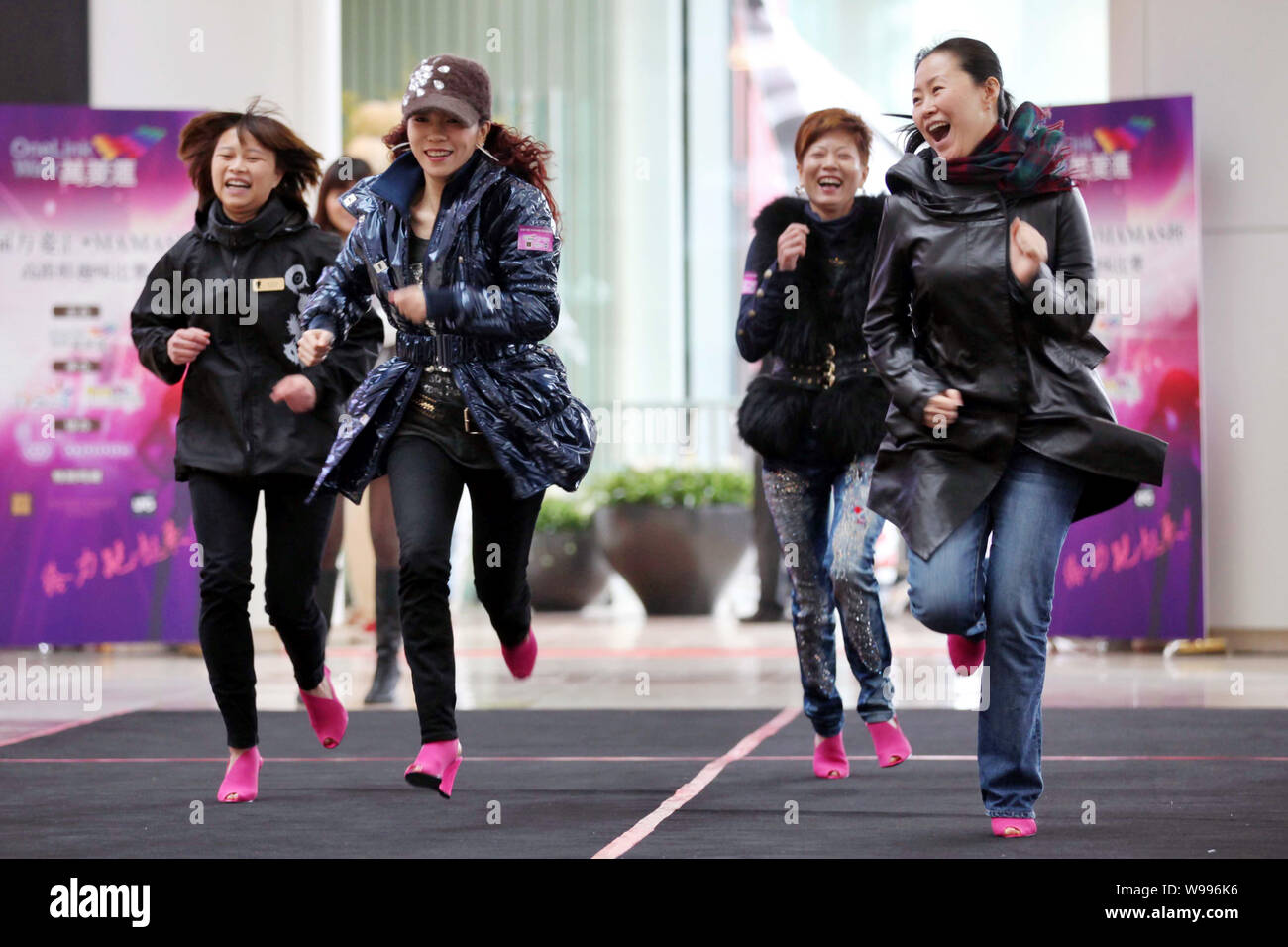 Young Chinese women wearing high-heel shoes compete in the shuttle run ...