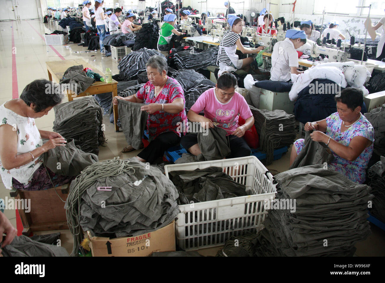 --File--Female Chinese workers process clothes to be exported to southeast Asian countries at ...
