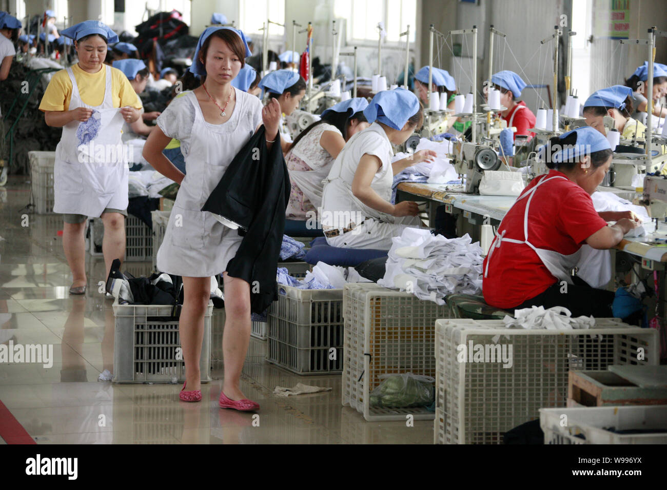 --File--Female Chinese workers process clothes to be exported to southeast Asian countries at ...