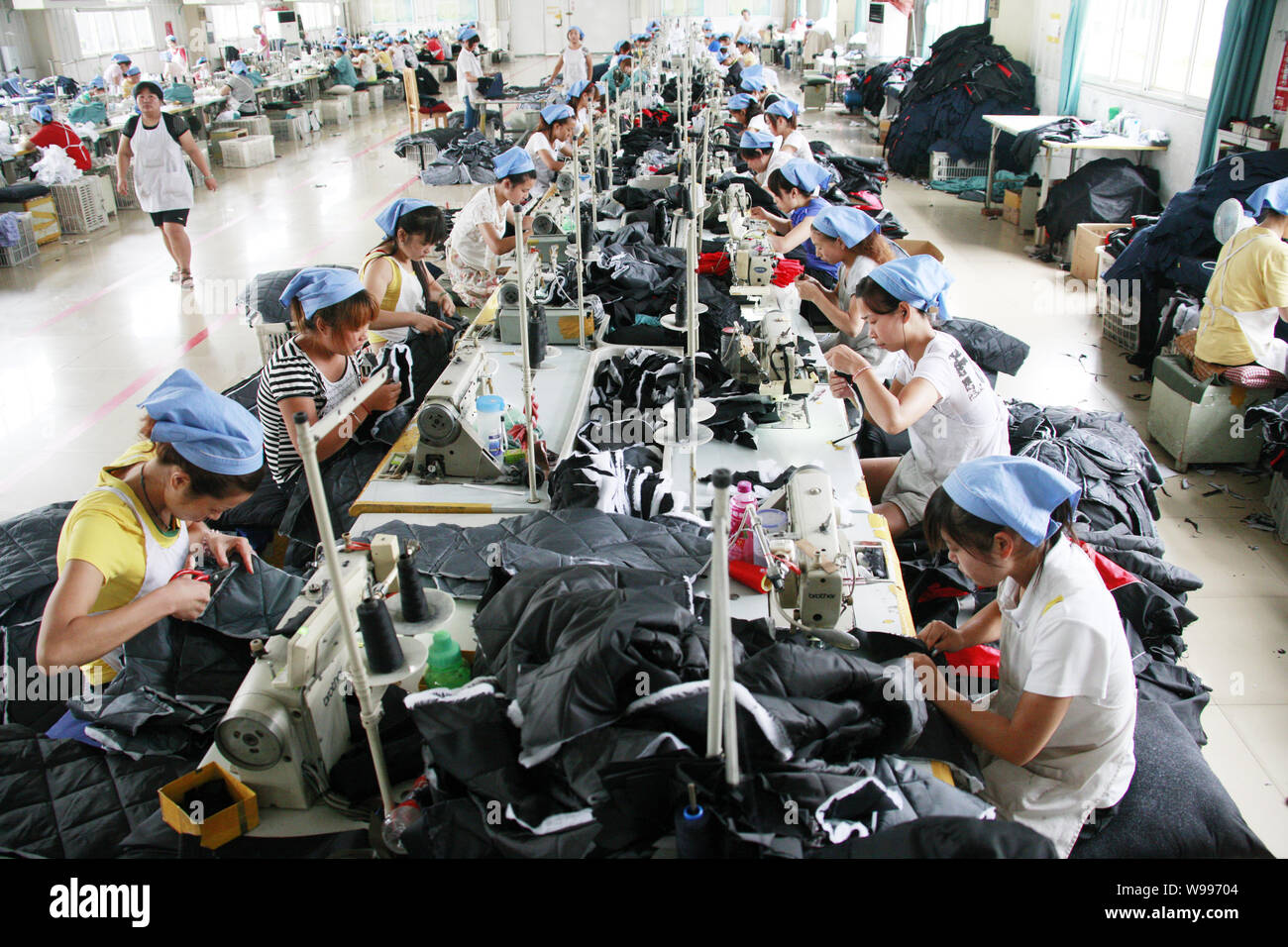 --File--Female Chinese workers sew clothes to be exported to southeast Asian countries at the ...