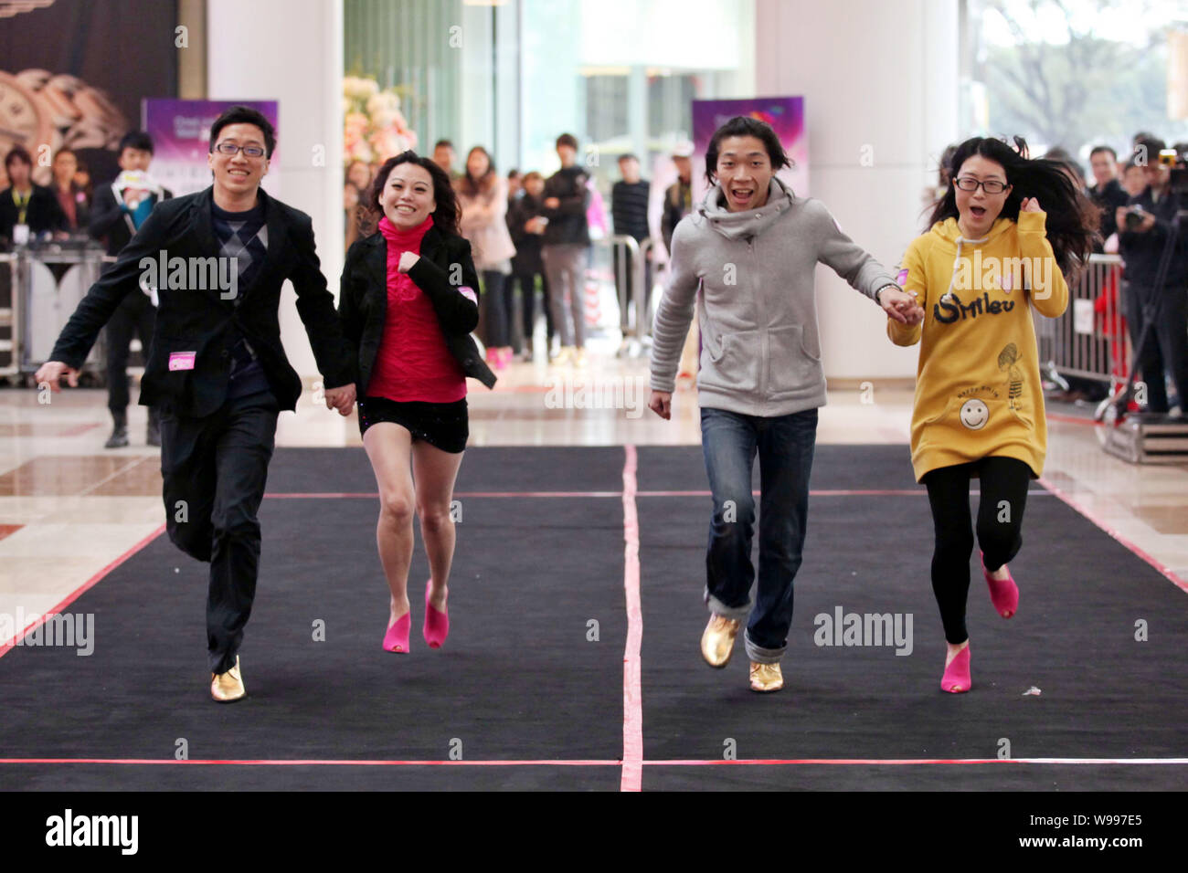 Young Chinese couples wearing high-heel shoes compete in the shuttle ...